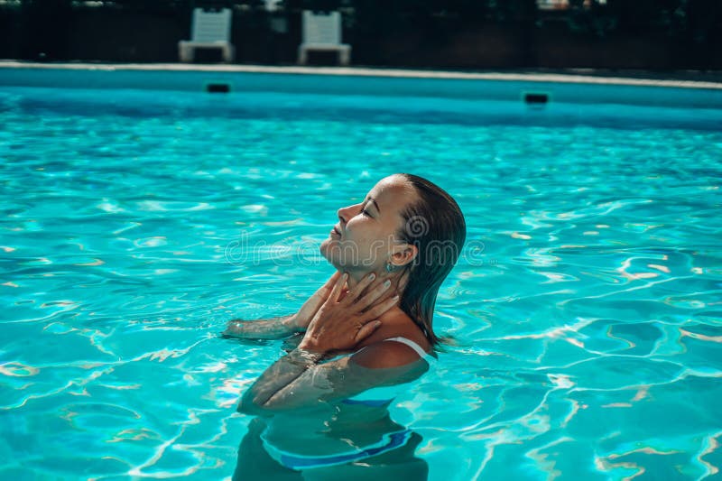 A Woman Is Swimming In A Pool She Is Smiling And Enjoying The Water
