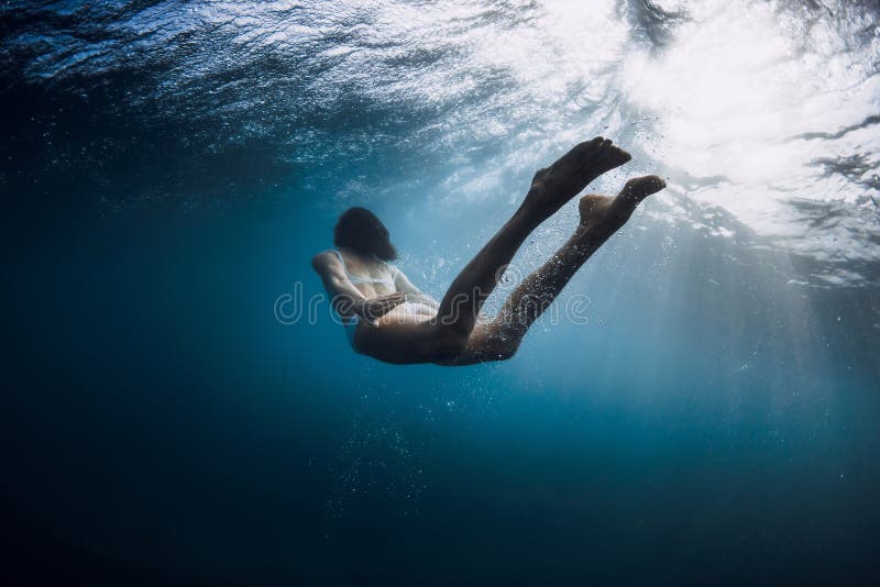Woman Underwater Swim Under Ocean Wave and Sun Rays Stock Image - Image ...