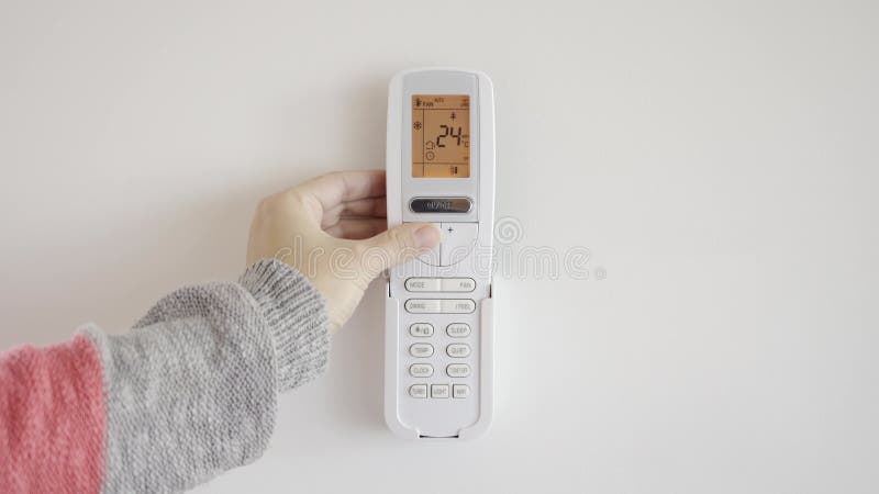 A Woman Switches the Air Conditioner To Cooling Mode Using a Remote ...