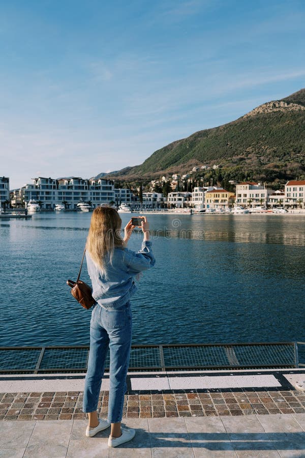 Woman Takes Pictures of High-rise Buildings on the Seashore with a ... Woman Takes Pictures of High-rise Buildings on the Seashore with a ...