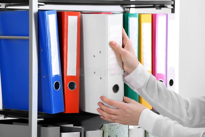 Woman Taking Folder with Documents from Shelf in Office, Closeup Stock ...