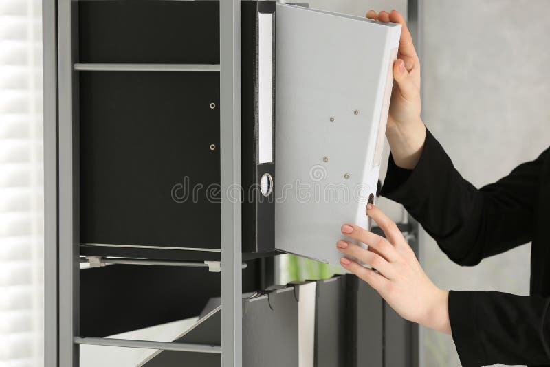 Woman Taking Folder with Documents from Shelf in Office, Closeup Stock ...
