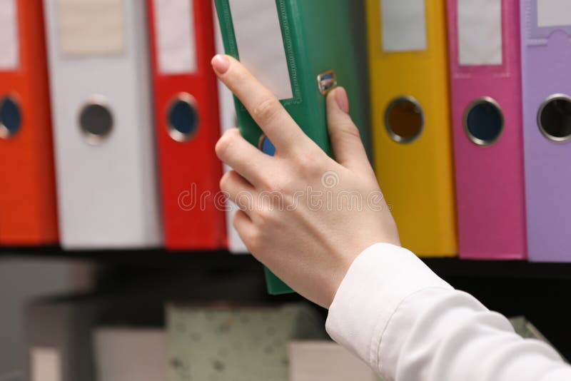 Woman Taking Folder with Documents from Shelf in Office, Closeup Stock ...