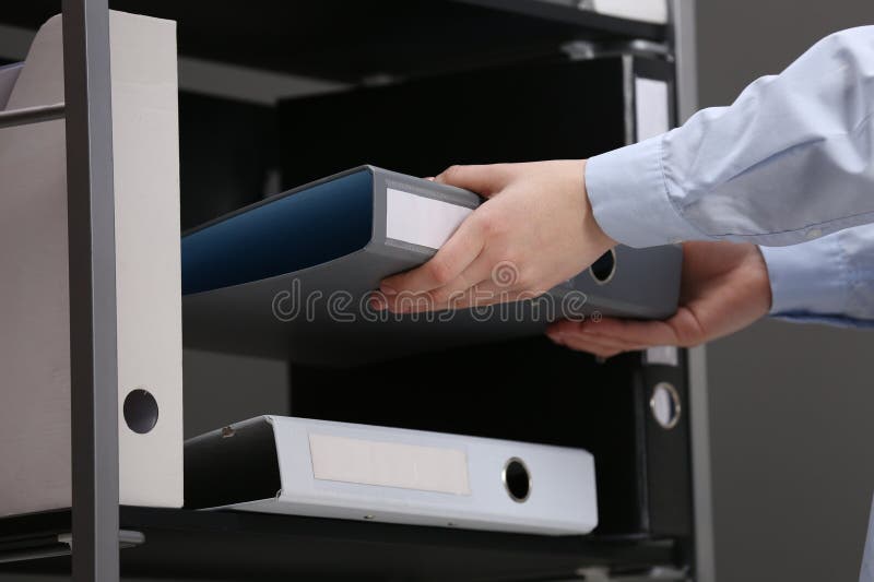 Woman Taking Folder with Documents from Shelf in Office, Closeup Stock ...