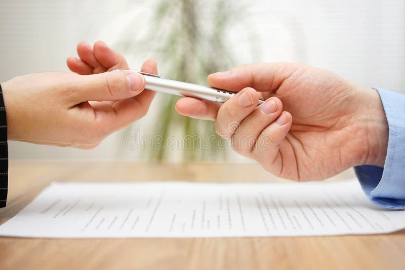 Two Business People Shaking Hands in the Background, Pen Lying on the ...