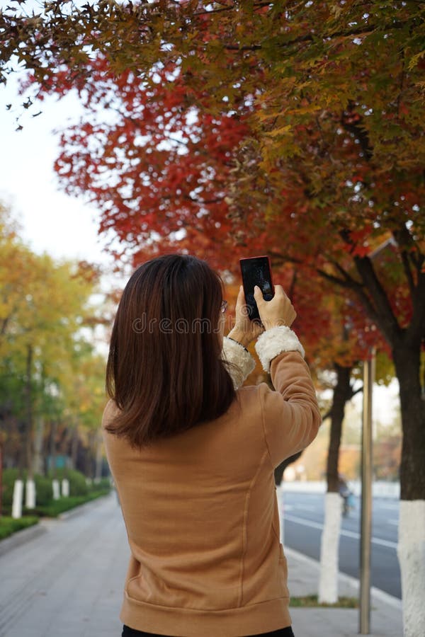 A Woman is Taking Photoes in Fall Editorial Image - Image of blue ...