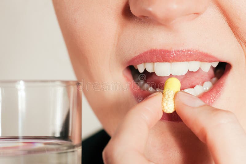 Woman taking a pill stock image. Image of yellow, open - 12357599