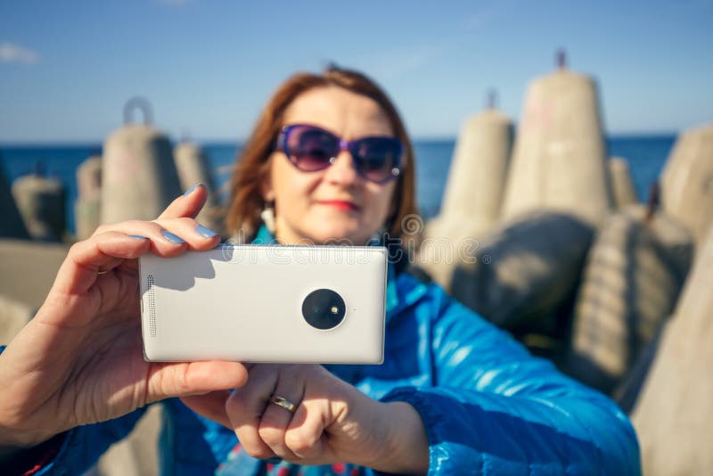 Woman taking self-portrait stock image. Image of sunglasses - 71305103