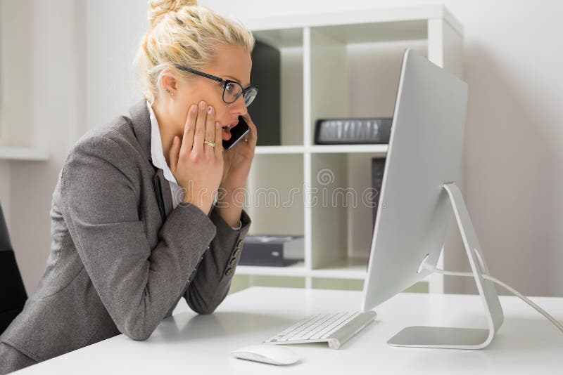 Woman Talking on the Phone and Looking at Computer in Shock Stock Image ...