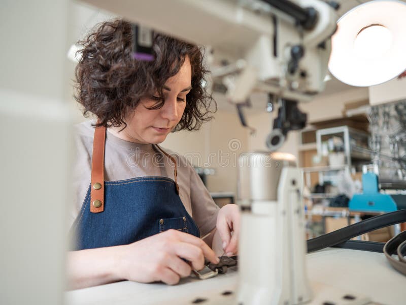 A Woman Tanner Sews a Leather Belt on a Sewing Machine. Stock Photo ...