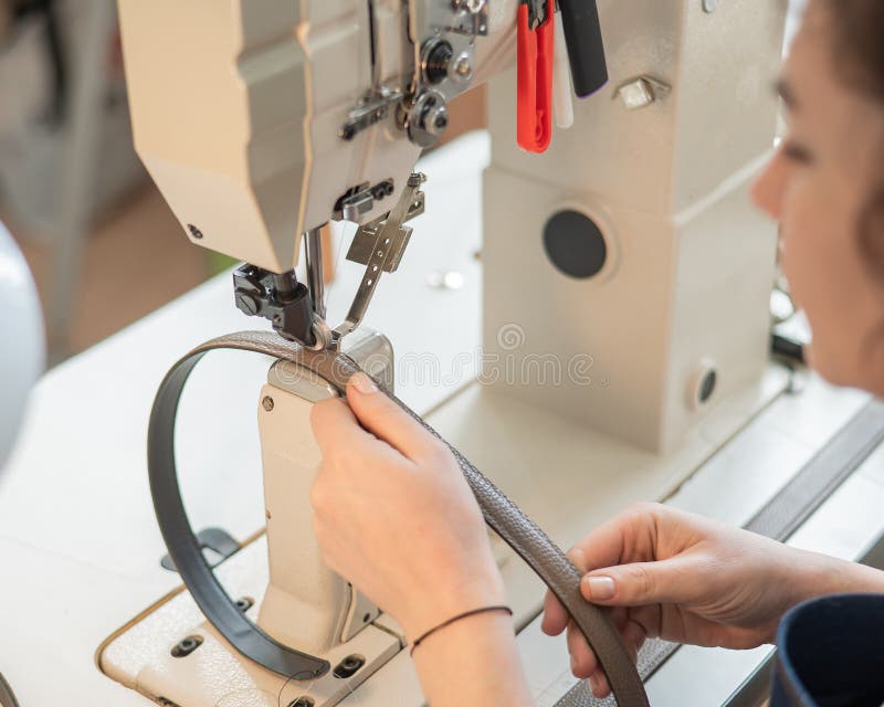 A Woman Tanner Sews a Leather Belt on a Sewing Machine. Stock Photo ...