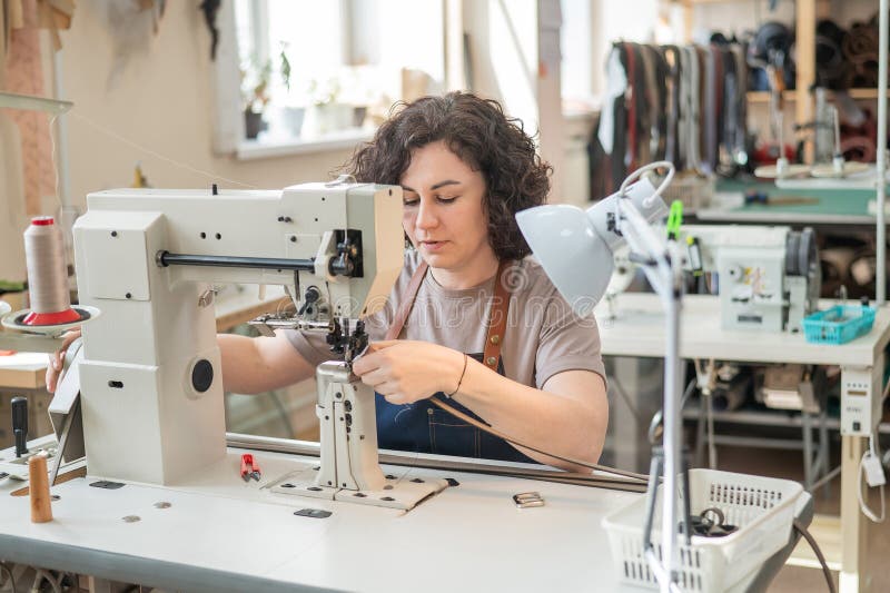 A Woman Tanner Sews a Leather Belt on a Sewing Machine. Stock Image ...