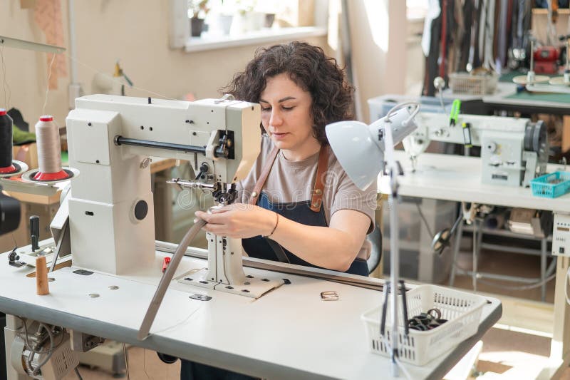 A Woman Tanner Sews a Leather Belt on a Sewing Machine. Stock Photo ...