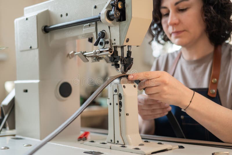 A Woman Tanner Sews a Leather Belt on a Sewing Machine. Stock Photo ...
