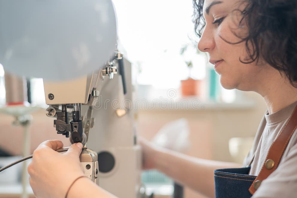 A Woman Tanner Sews a Leather Belt on a Sewing Machine. Stock Photo ...