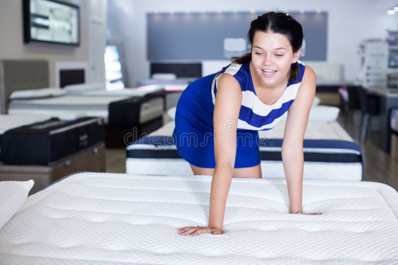 Woman testing mattress stock image. Image of bedroom - 212873493