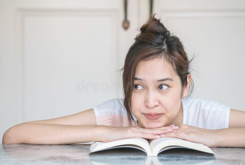 Woman with Thinking Face with a Book on Marble Table in Front of House ...