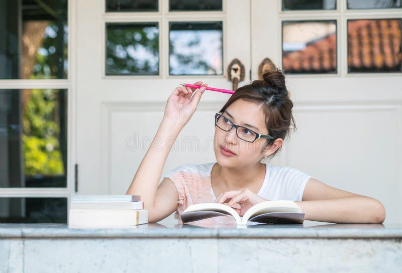Woman with Thinking Face with a Book on Marble Table in Front of House ...