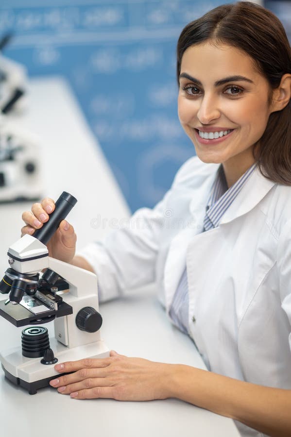 Woman Touching Microscope Smiling at Camera Stock Image - Image of ...