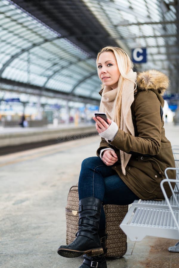 Woman on train station platform waiting. - Stock Image - Everypixel