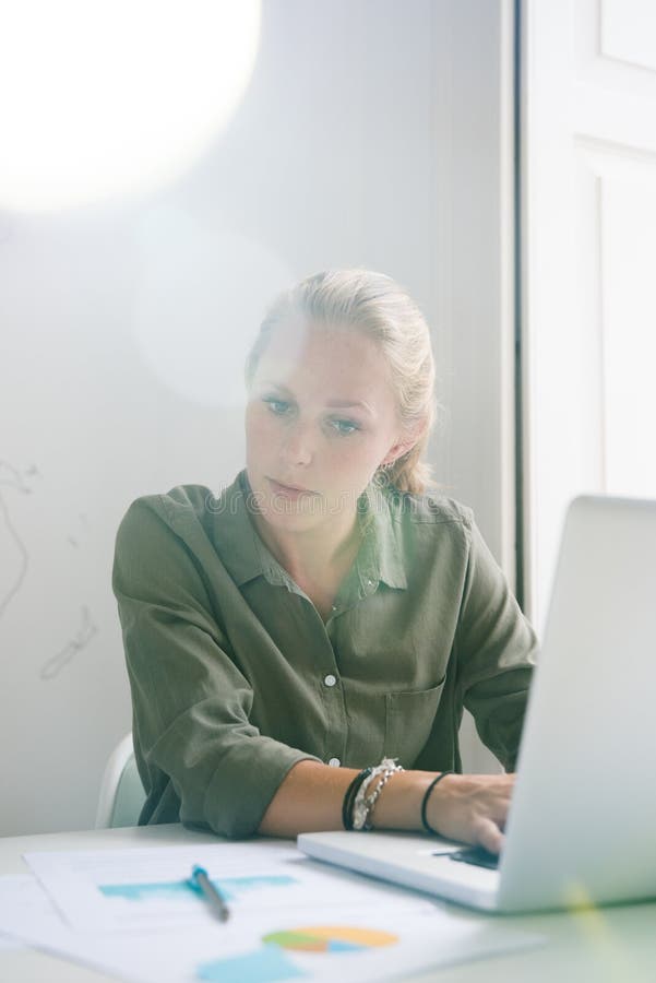 Woman Typing of a Laptop Looking at Documents Stock Photo - Image of ...