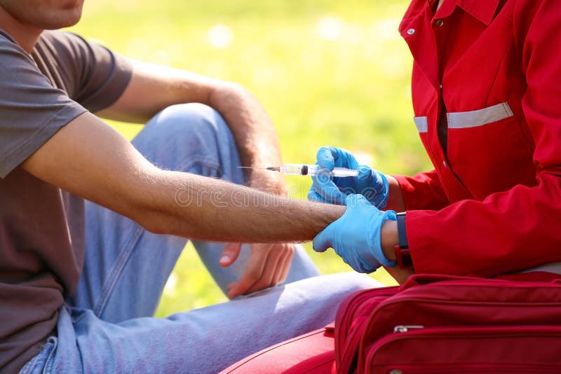 Woman in Uniform Performing CPR on Unconscious Man Outdoors. Stock ...