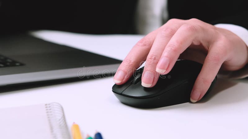 A Woman Uses a Computer Mouse while Working on a Laptop at a Table in ...