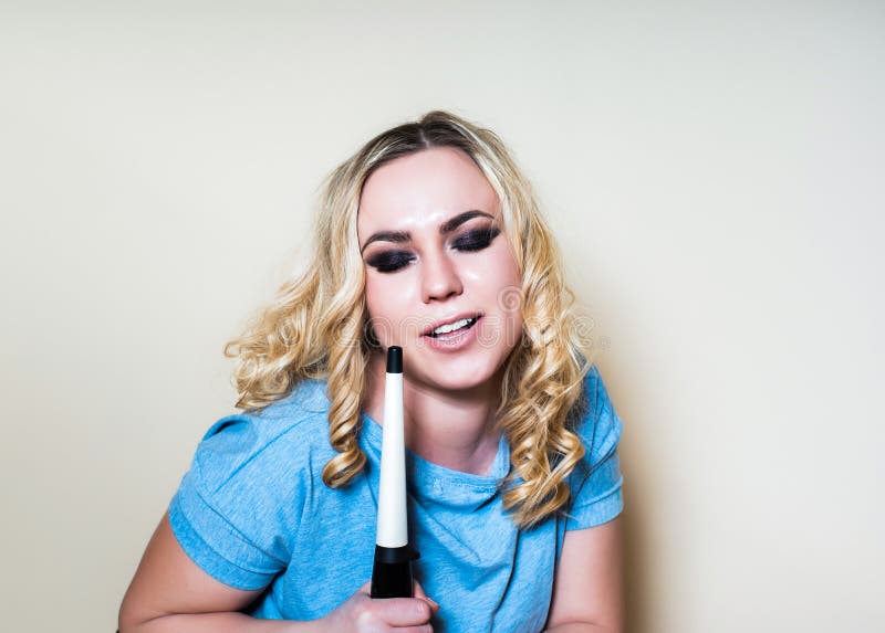 A Woman Uses a Hair Accessory As a Microphone for Singing Stock Image ...