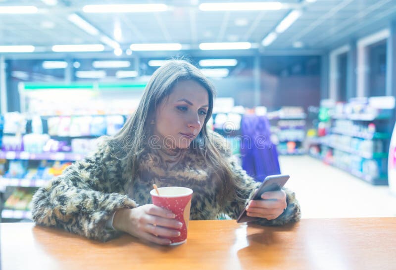 Woman Using App on Smartphone and Drinking Coffee in Cafe Stock Photo ...
