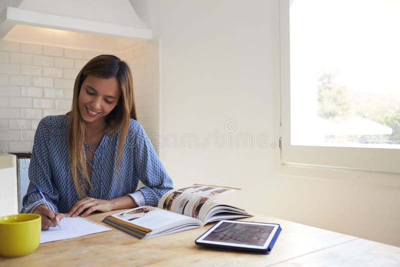 Woman Using Book and Tablet Writing in Kitchen, Close Up Stock Photo ...
