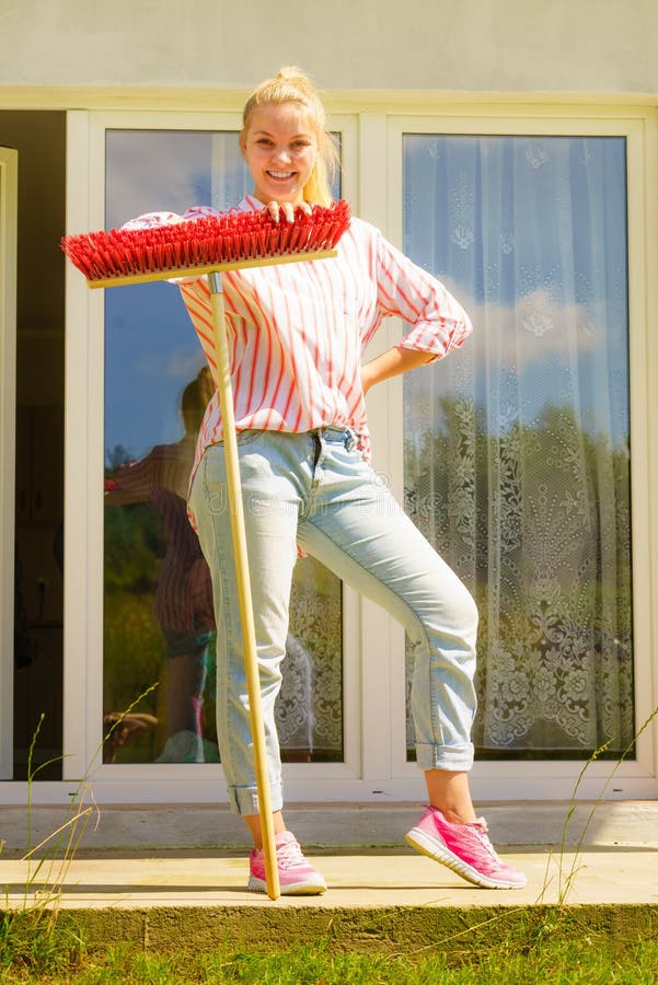 Woman Using Broom To Clean Up Backyard Patio Stock Foto - Image of werk ...