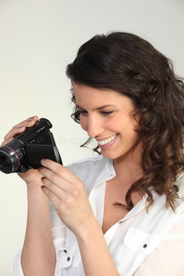 Woman using a camcorder stock image. Image of features - 27809919