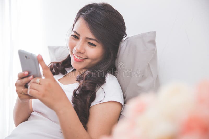 Woman Using Cellphone on the Bed Stock Image - Image of happy ...