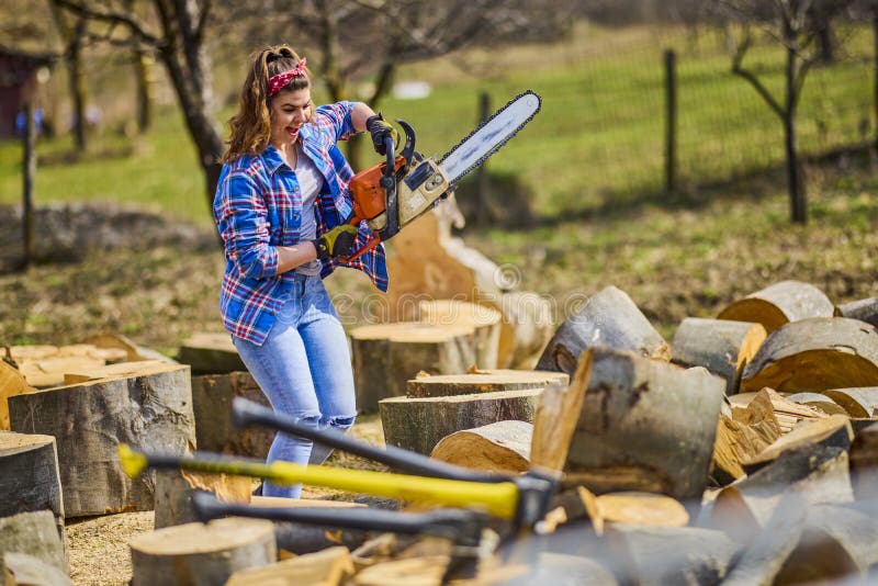 Woman Using Chainsaw To Cut a Log for Firewood Stock Photo - Image of ...