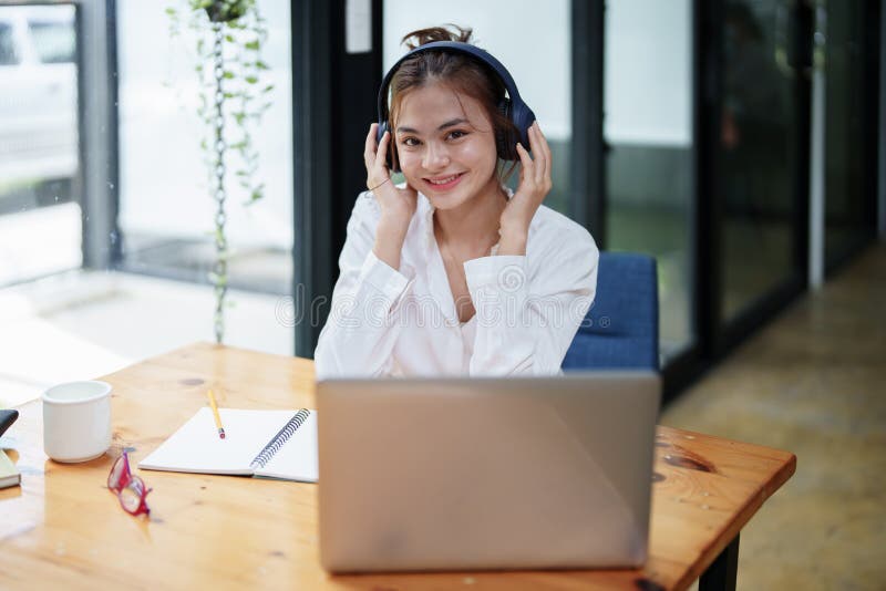 Woman Using a Computer and Earphone during a Video Conference Stock ...