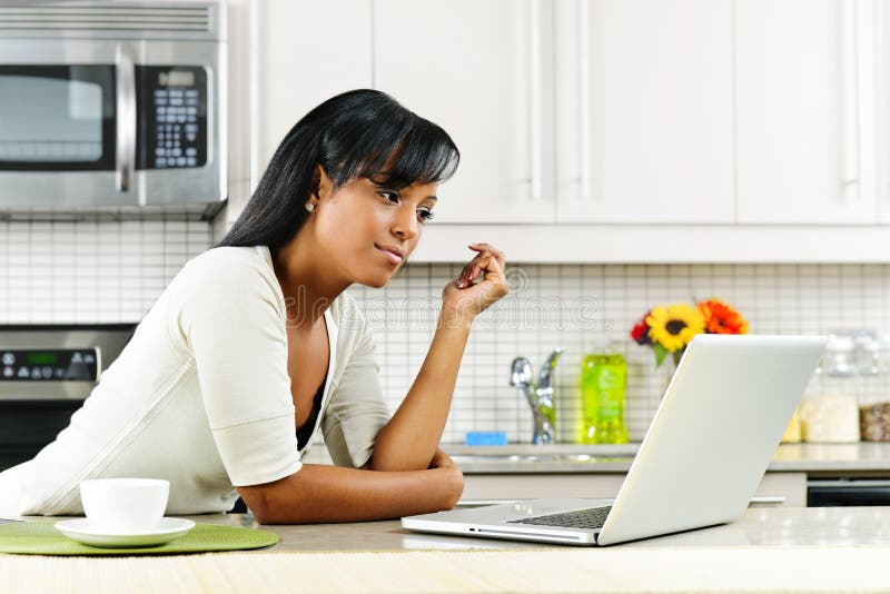 Woman Using Computer in Kitchen Stock Image - Image of looking, house ...
