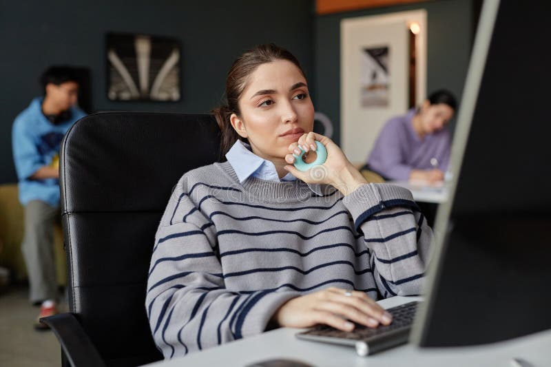 Woman Using Computer in Office and Using Hand Expander Stock Photo ...