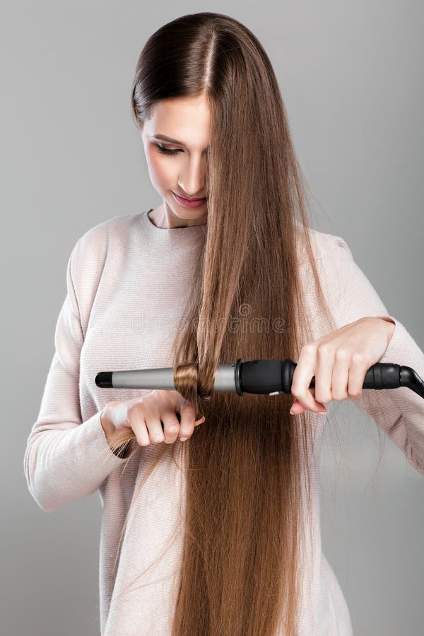 Woman using curling iron. stock photo. Image of curler - 104268648