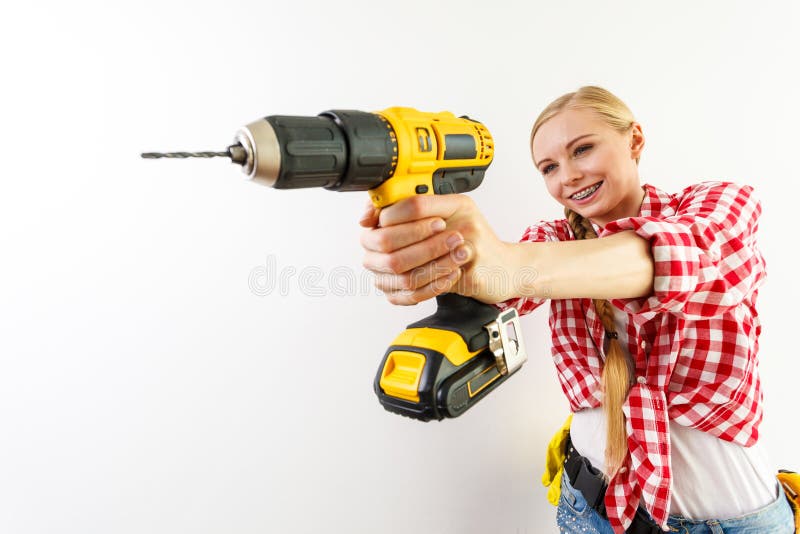 Woman using drill on wall stock photo. Image of constructor - 130100450