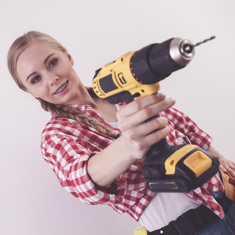 Woman using drill on wall stock photo. Image of home - 138217392