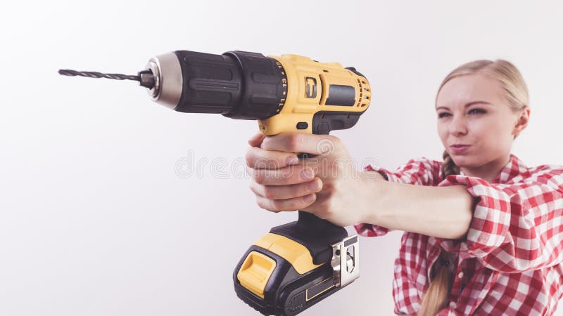 Woman using drill on wall stock image. Image of home - 143044575