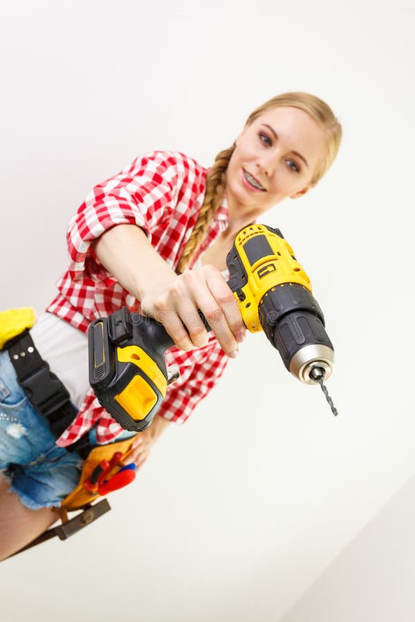 Woman using drill on wall stock image. Image of constructor - 203150457