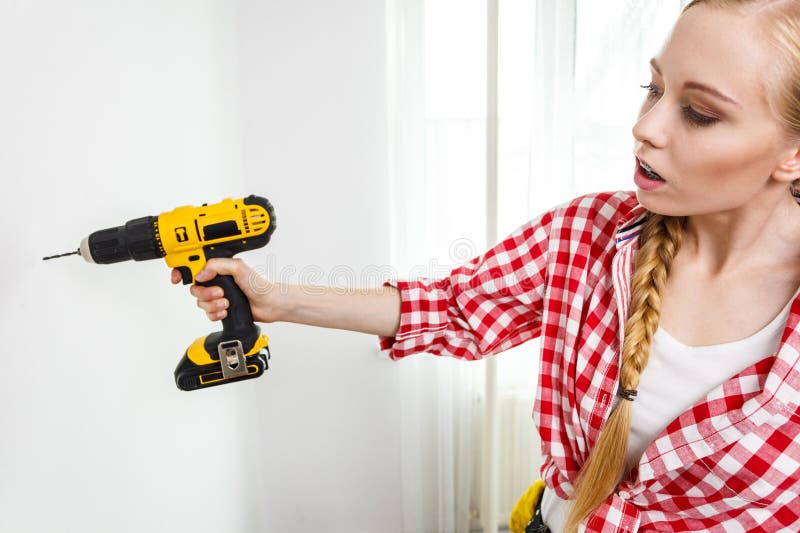 Woman using drill on wall stock photo. Image of work - 279051782