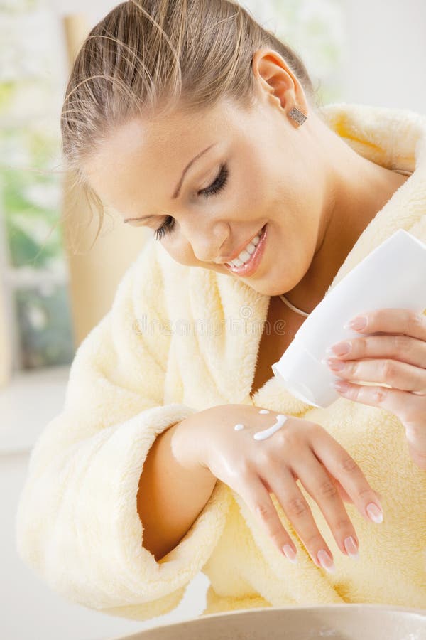 Woman using hand cream stock image. Image of expression - 11200387