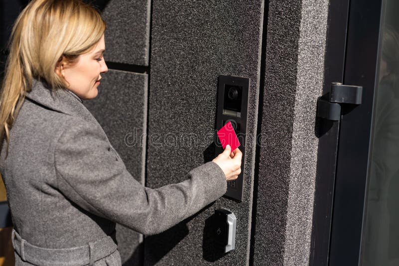 Woman Using Intercom at Building Entrance. Stock Image - Image of ...