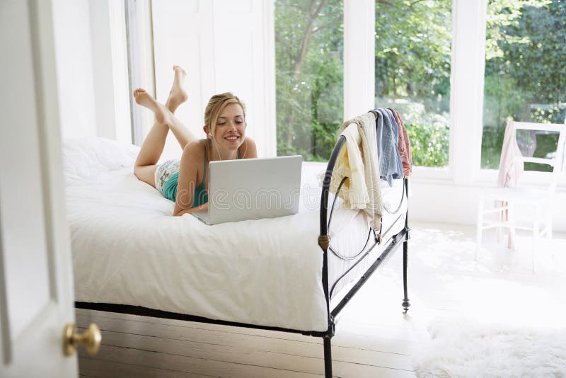 Woman Using Laptop in Bed stock image. Image of concept - 31835089