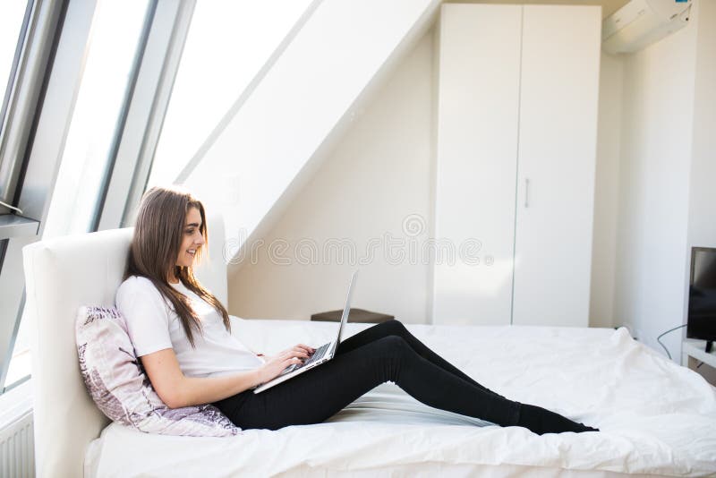 Woman using laptop in bed stock photo. Image of female - 83139956