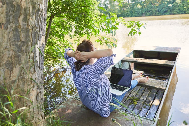 Woman Using Laptop in a Boat on the Lakeshore on Vacation Stock Image ...