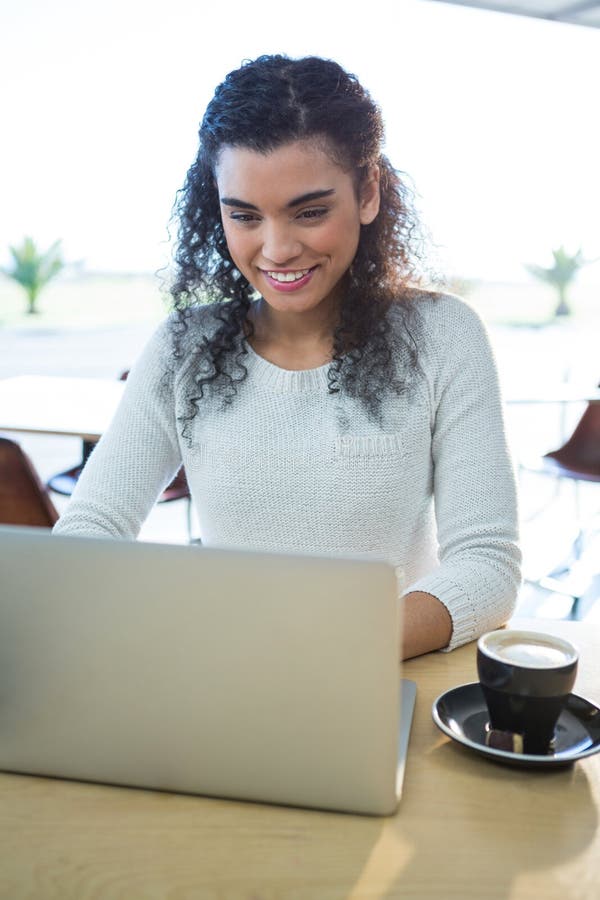 Woman Using Laptop and a Coffee Cup on the Table in the Coffee Shop ...