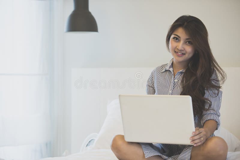 Woman Using a Laptop Computer while Lying on Her Bed Stock Photo ...